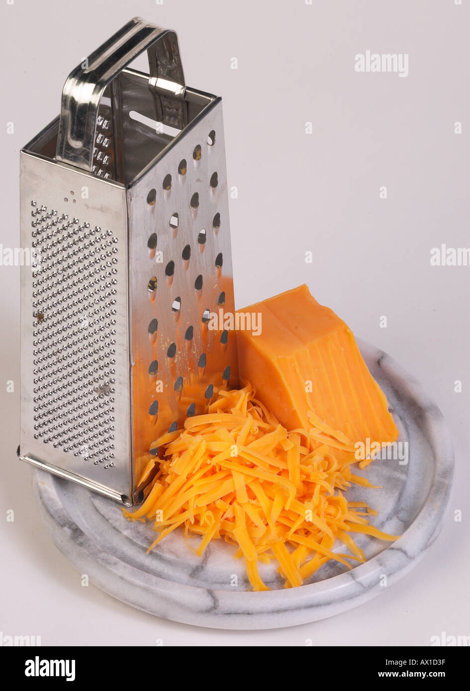 Cheddar cheese and grater on marble plate L2 Stock Photo - Alamy