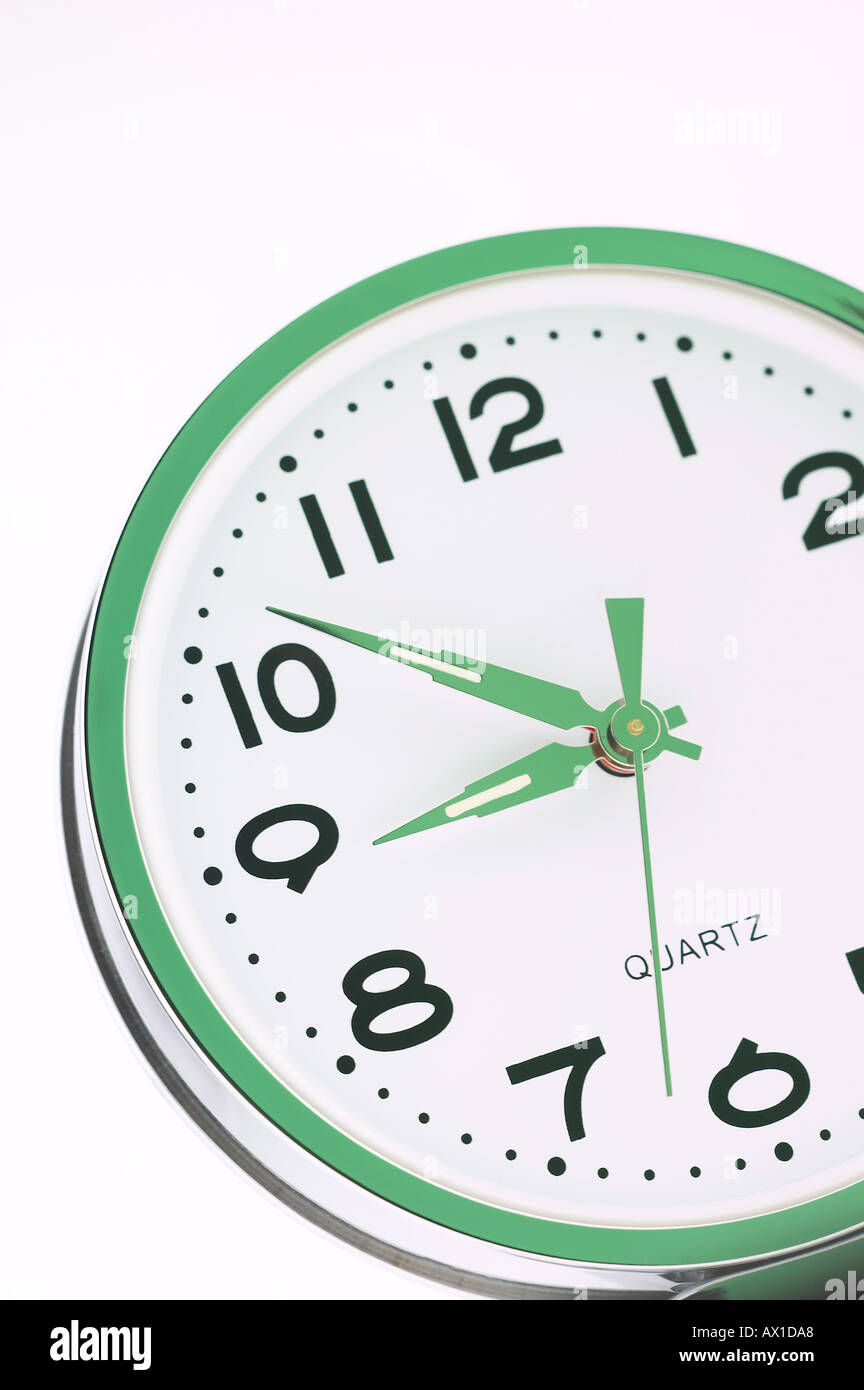 Green and white clock on white surface Stock Photo - Alamy