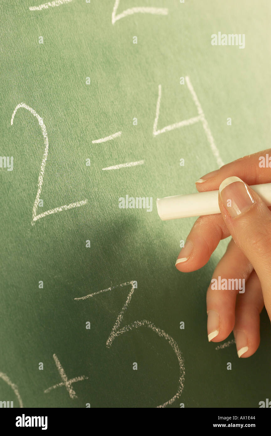 Teacher writing math equation on chalkboard Stock Photo - Alamy