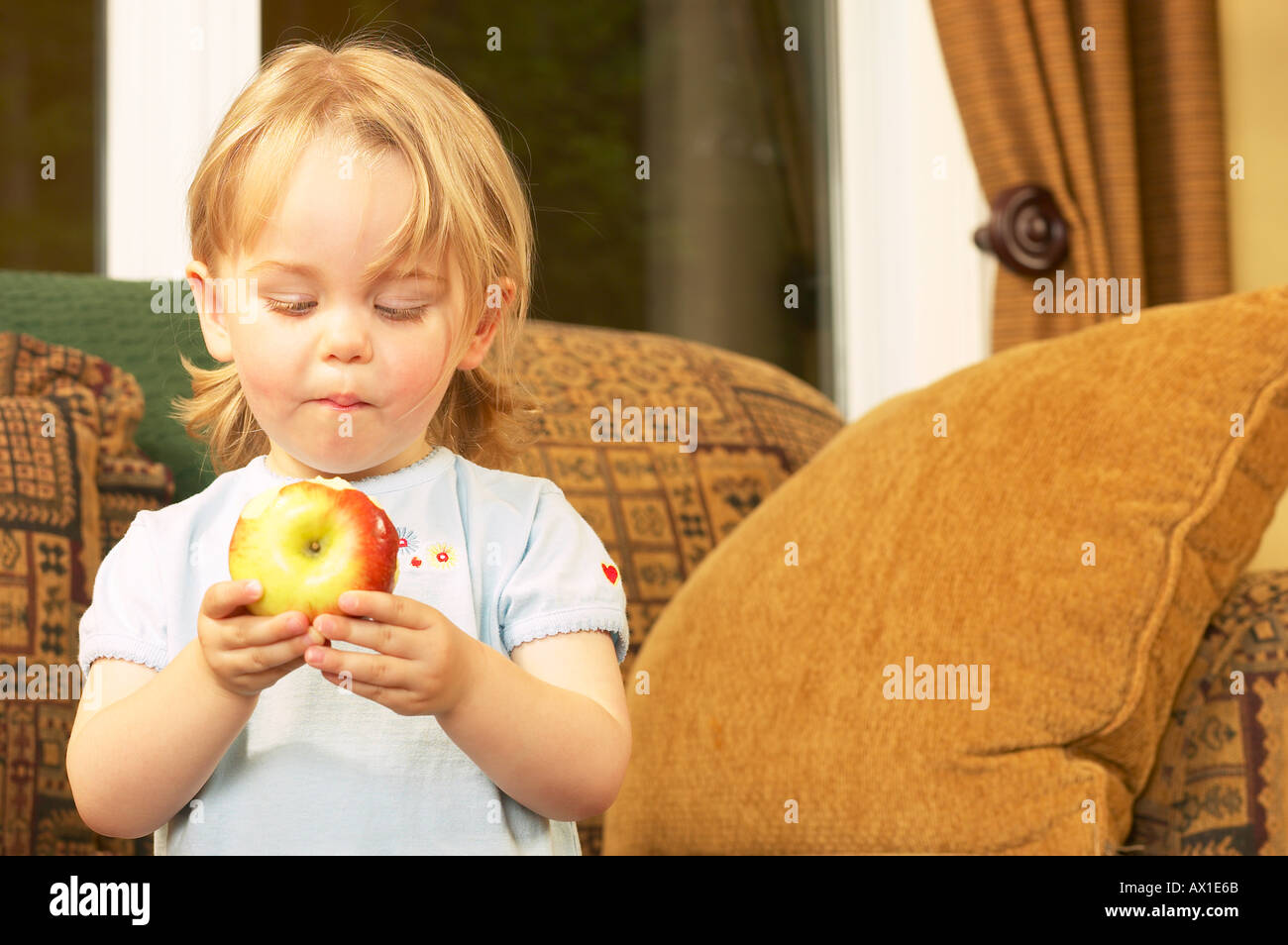 Little girl eating apple Stock Photo - Alamy