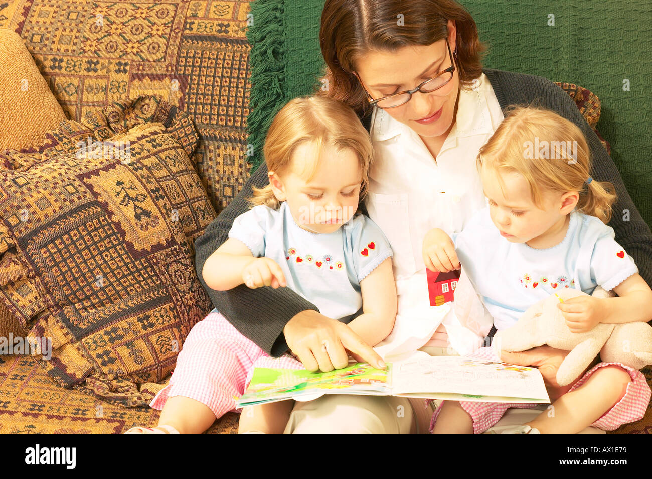 Mother reading story with twin little girls 1 Stock Photo - Alamy