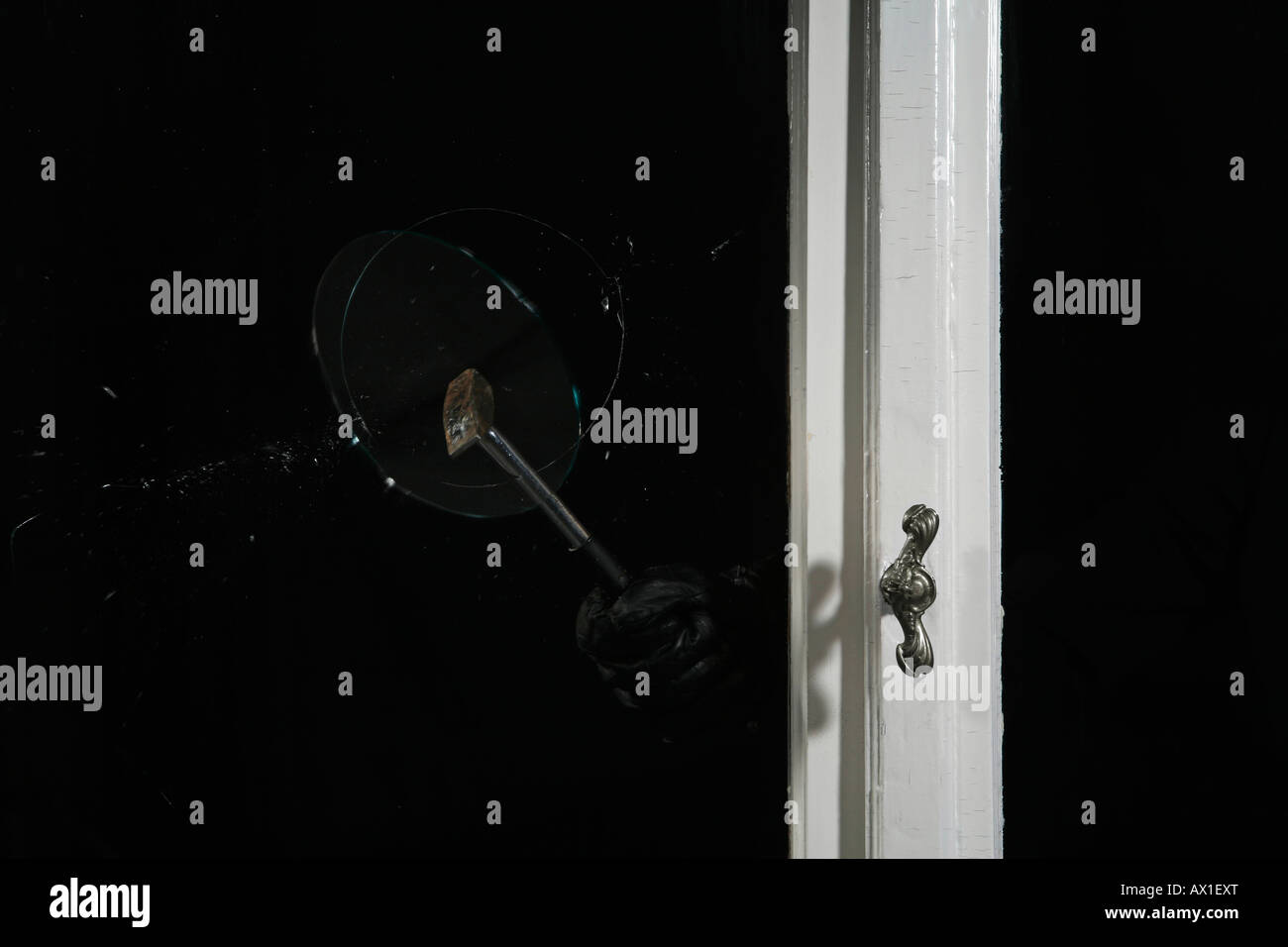 A gloved hand breaking a window with a hammer Stock Photo - Alamy