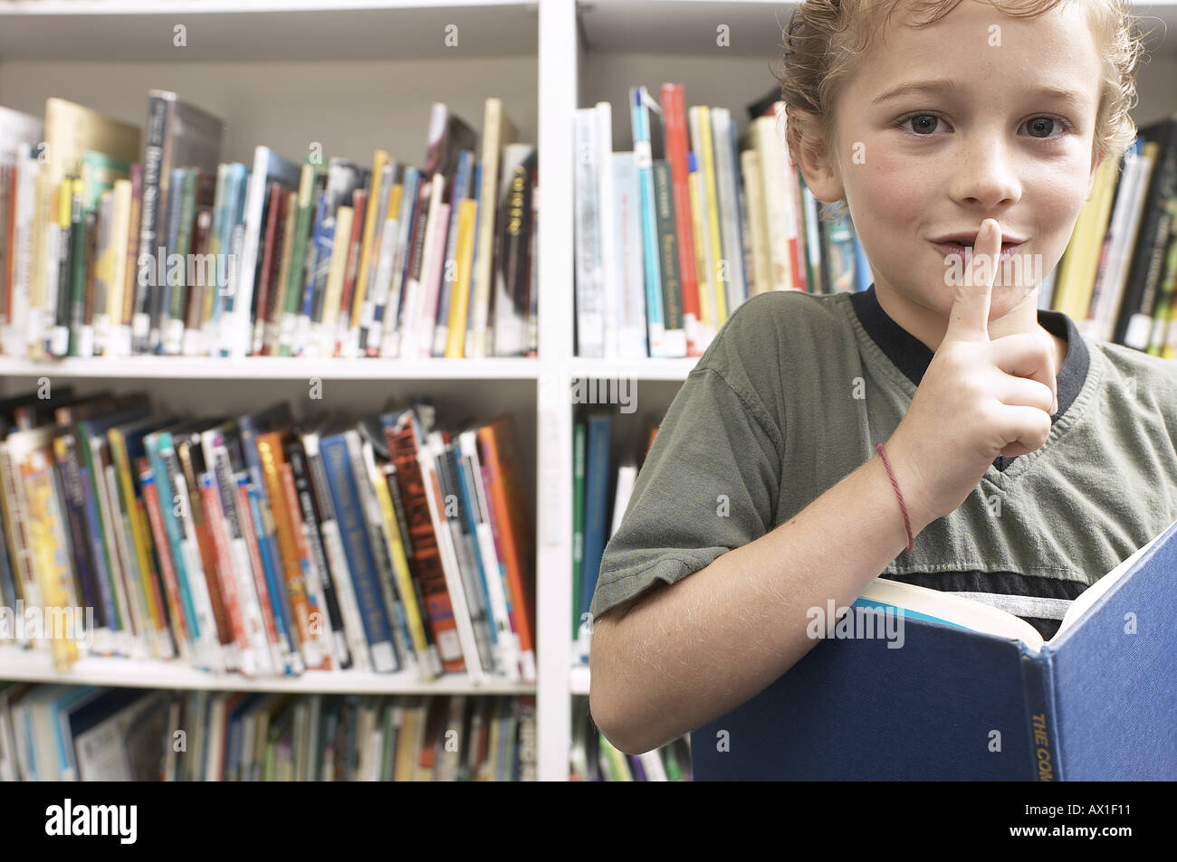 Quiet little boy reading library book Stock Photo - Alamy