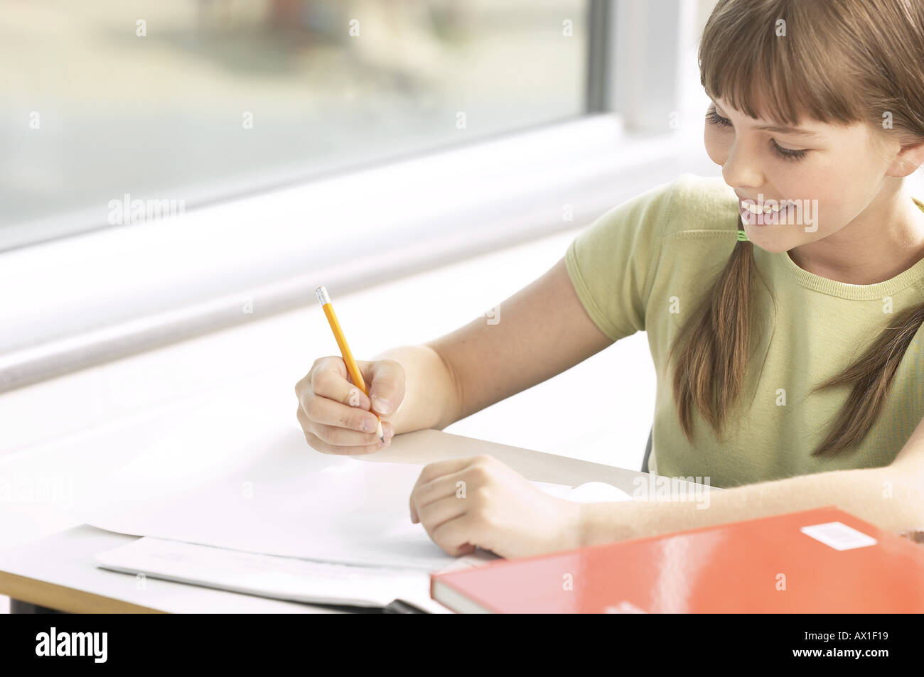 Little girl writing at her desk 2 Stock Photo - Alamy