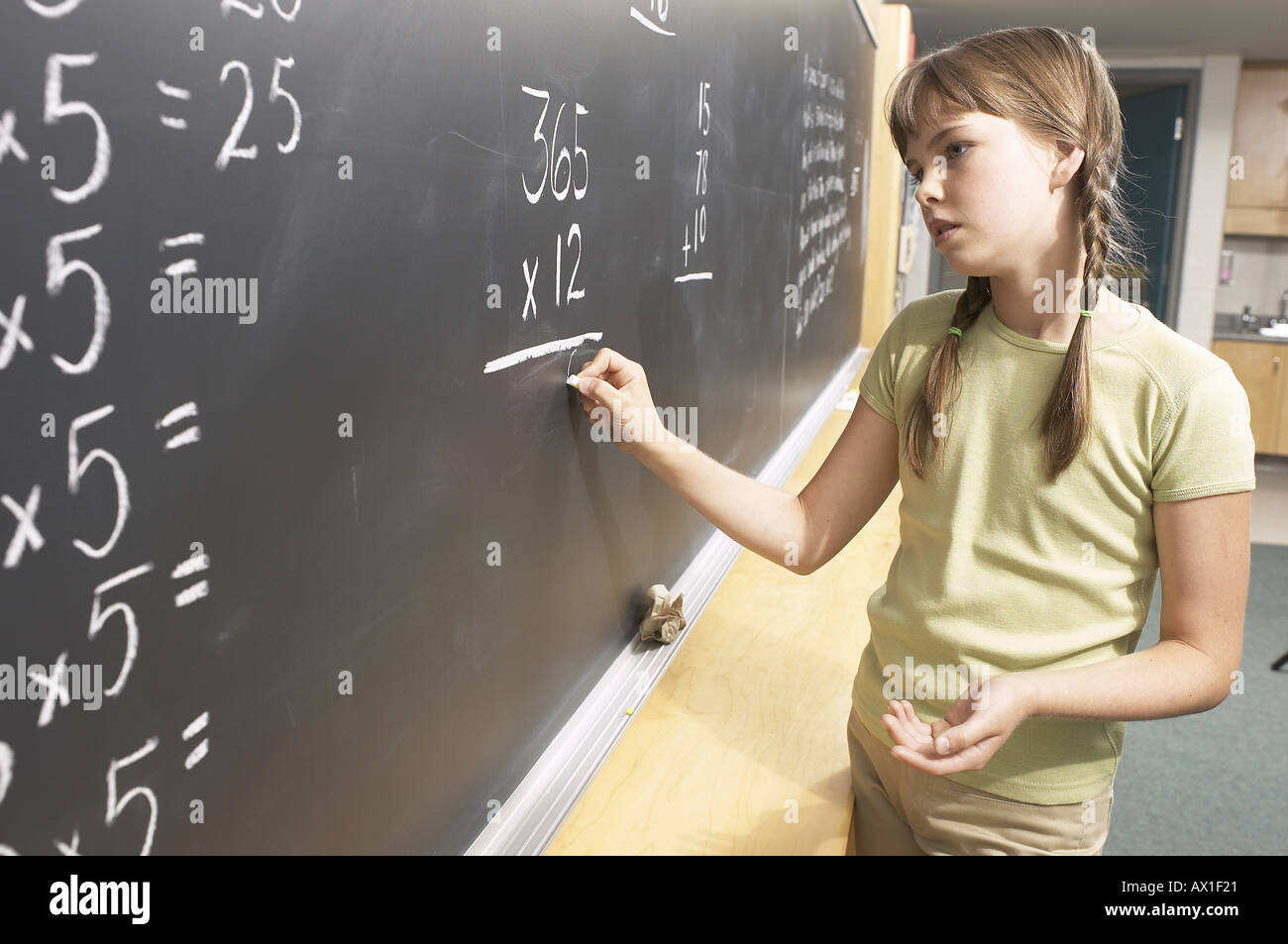 Little girl doing math equations on the blackboard 1 Stock Photo - Alamy