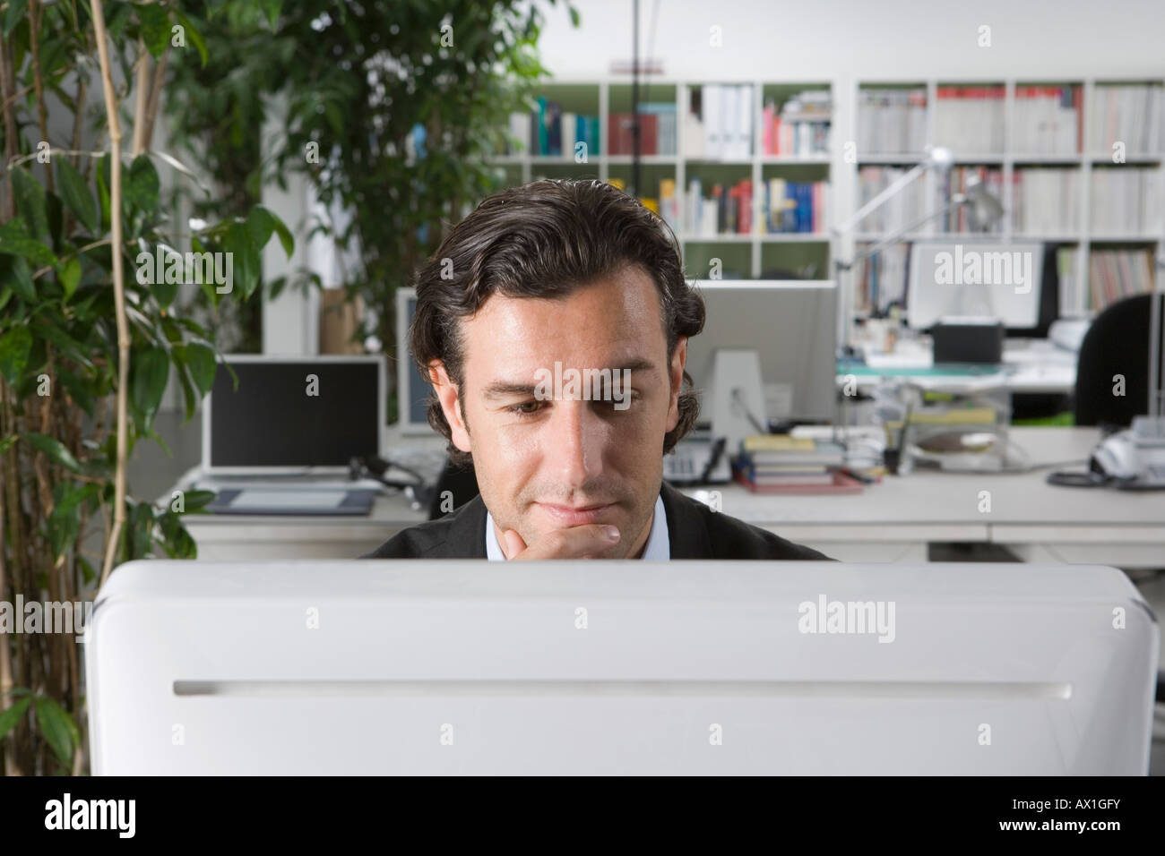 A businessman using a computer in an office Stock Photo - Alamy