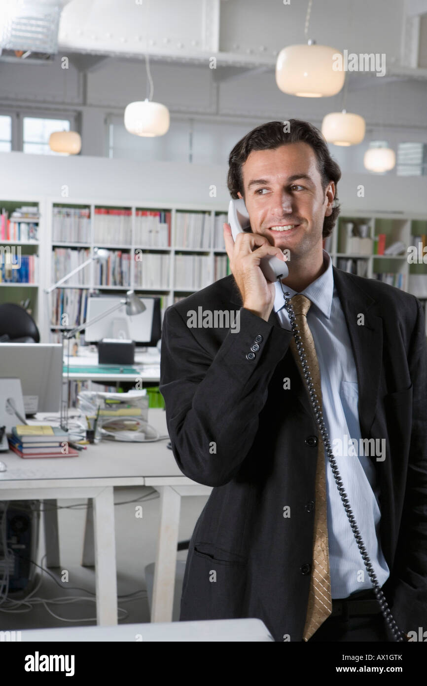 A businessman using a telephone in an office Stock Photo - Alamy