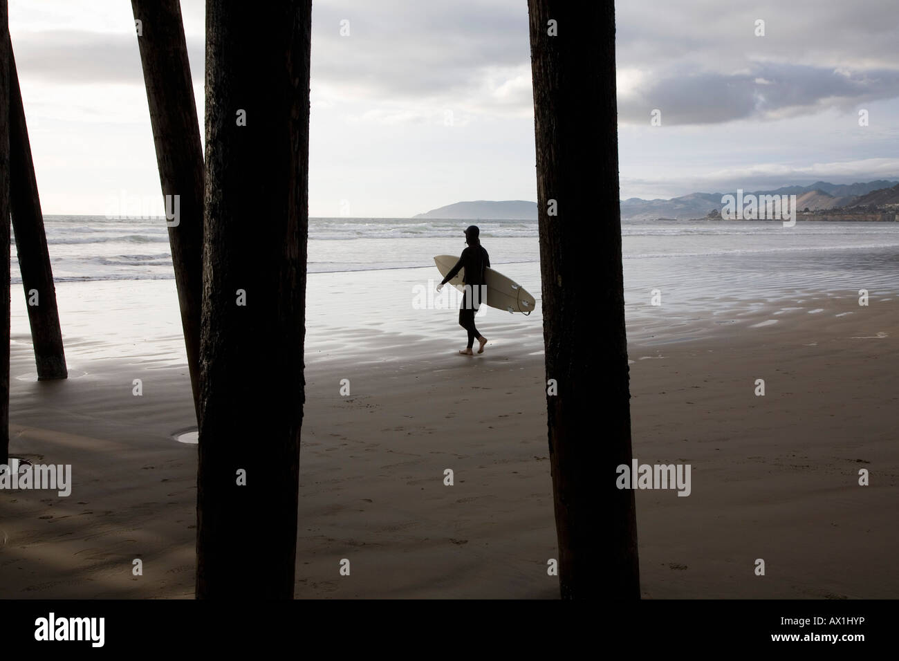 A surfer walking on the beach Stock Photo - Alamy