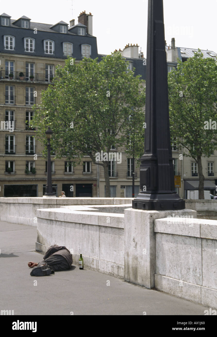 Homeless man lying down on bridge Paris France Stock Photo - Alamy