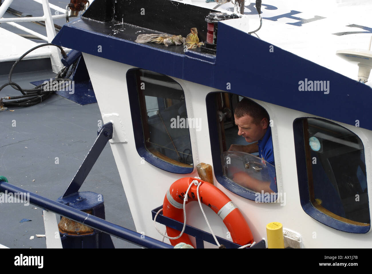 Fishing boat trawler captain in wheelhouse Mallaig Scotland Stock Photo ...