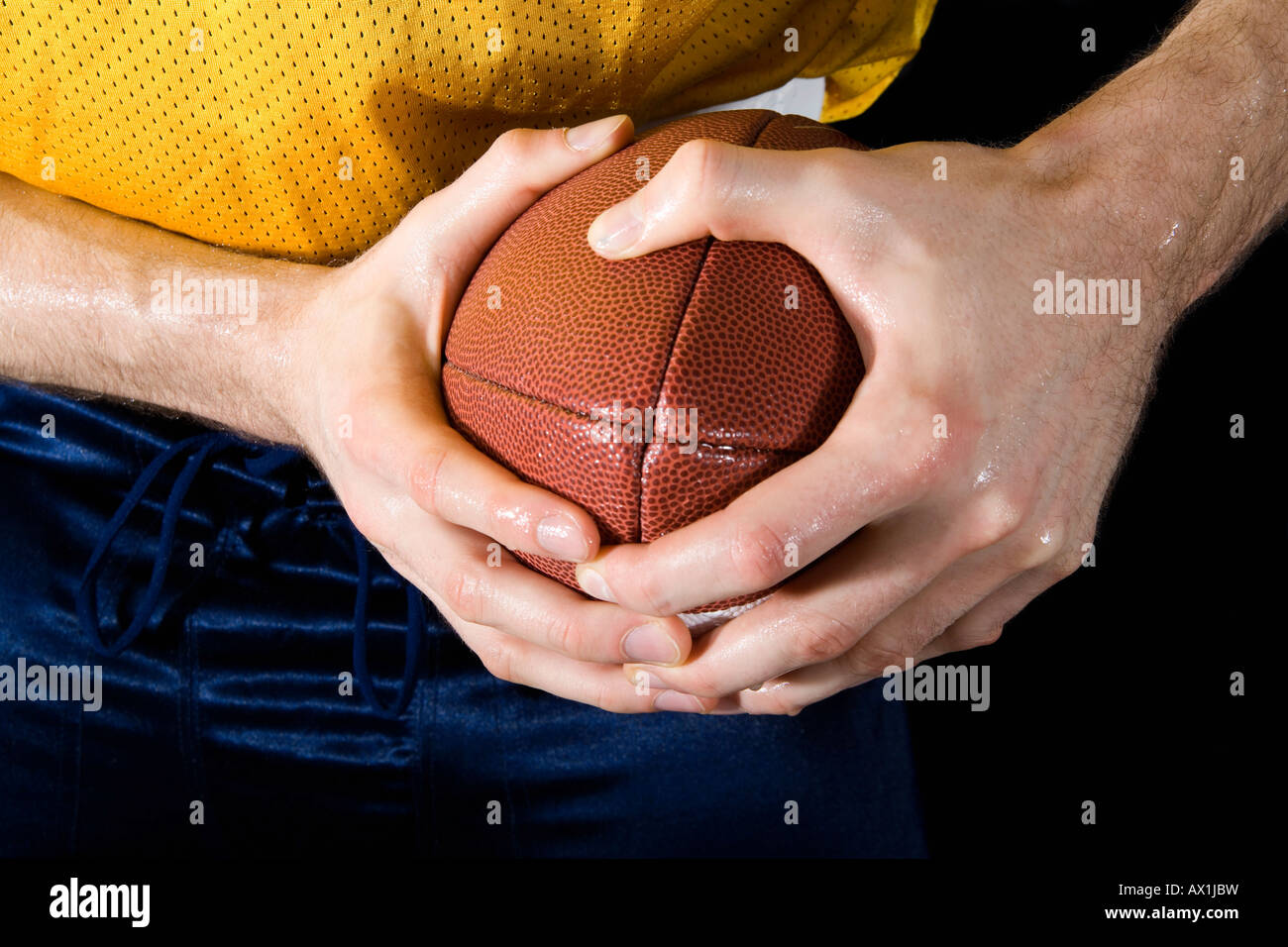 An American football player holding a ball Stock Photo - Alamy