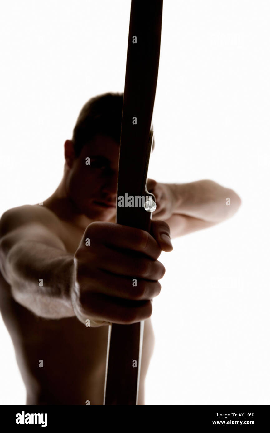 Silhouette of archer pulling an arrow back on his longbow Stock Photo ...