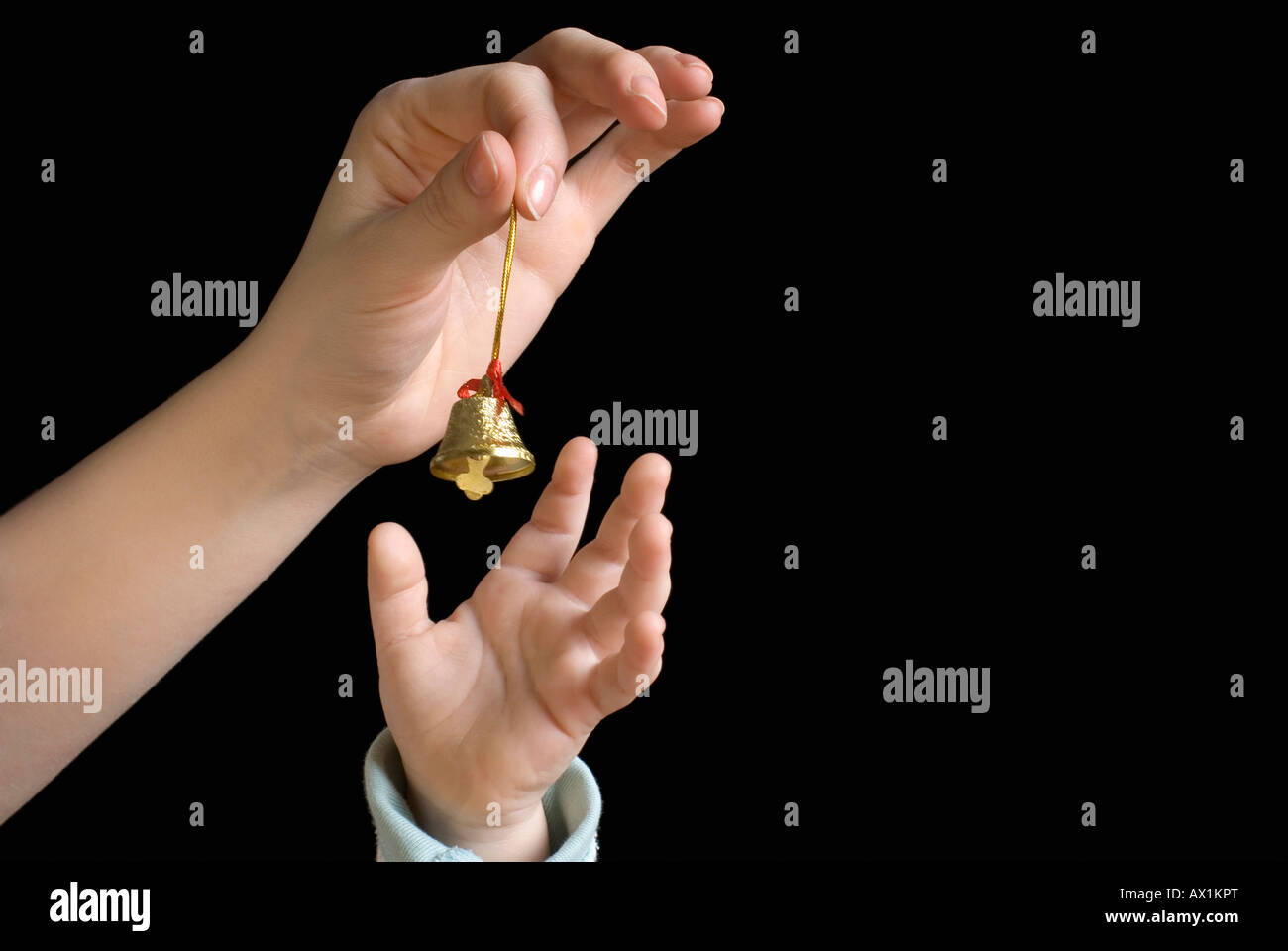Two hands and a small bell Stock Photo - Alamy