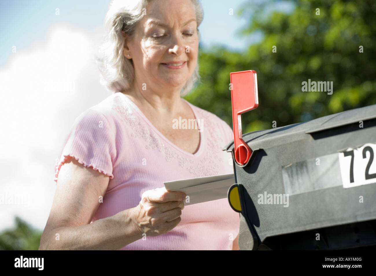 A senior woman checking the mailbox Stock Photo - Alamy