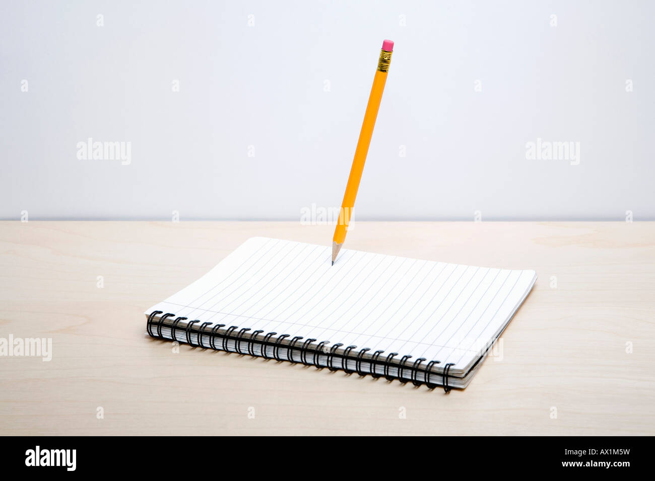 A pencil balancing on a notepad Stock Photo - Alamy