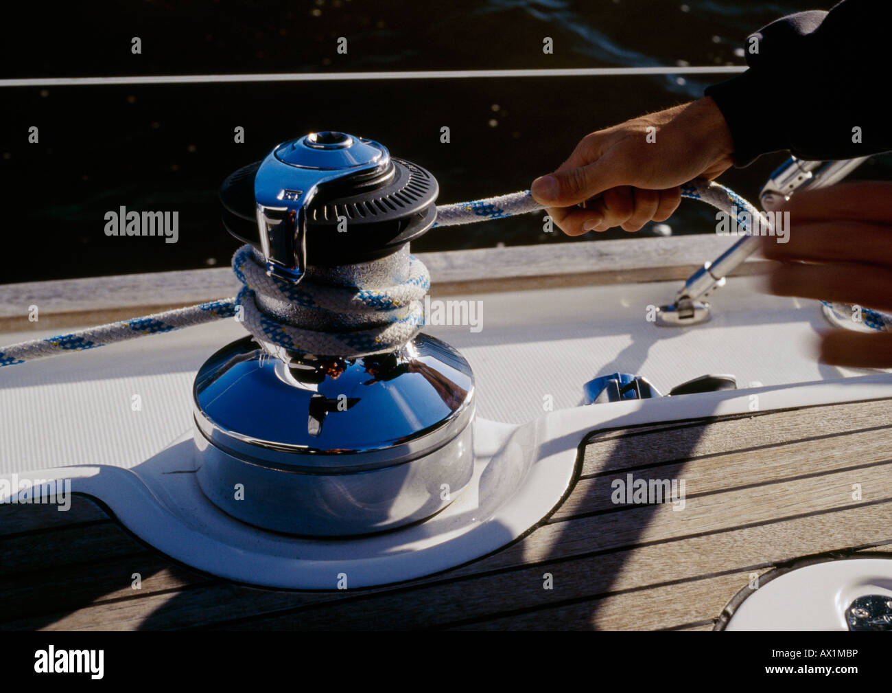 A person winding rope around a crank on a yacht Stock Photo - Alamy