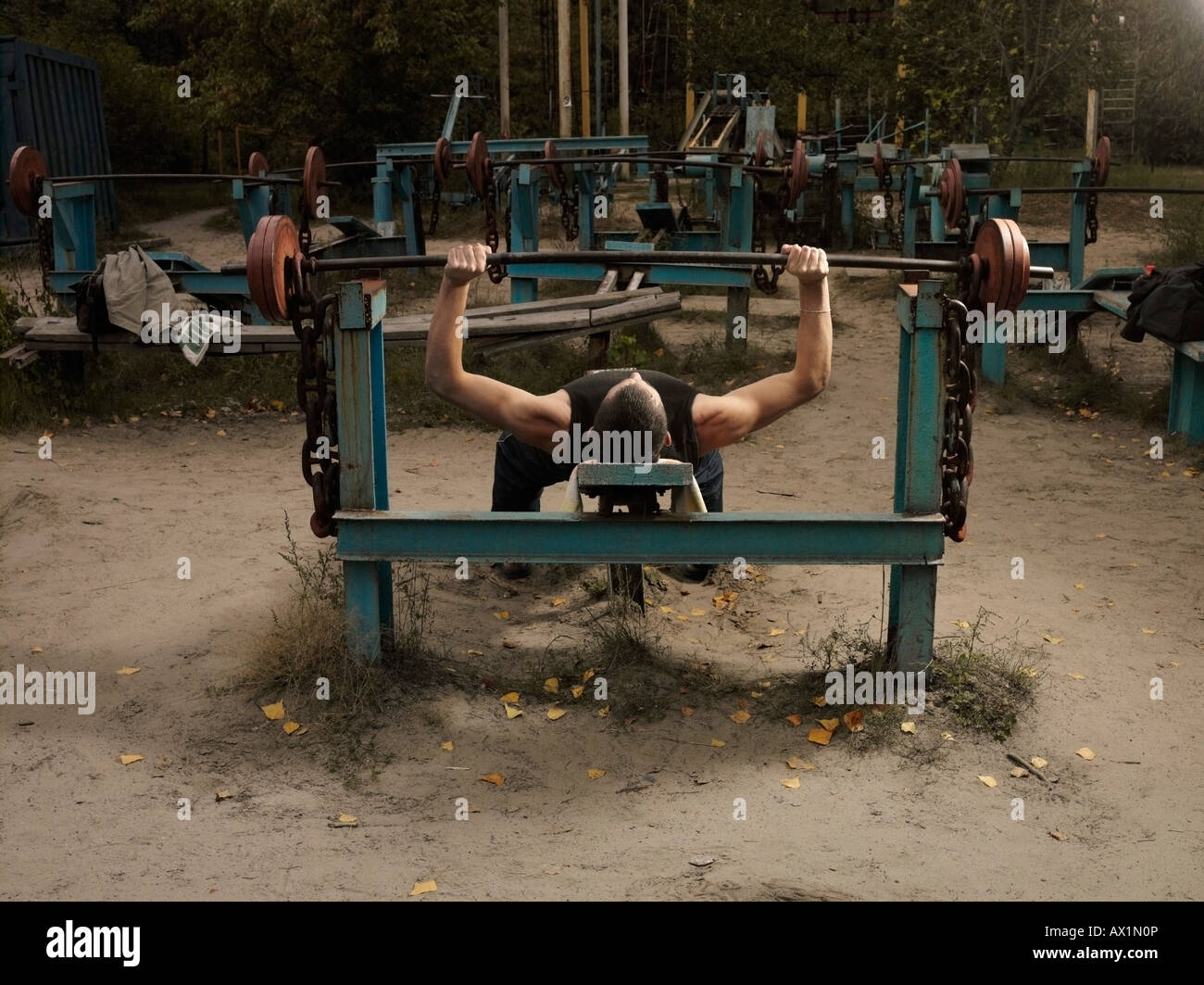 A man lifting weights outside Stock Photo - Alamy