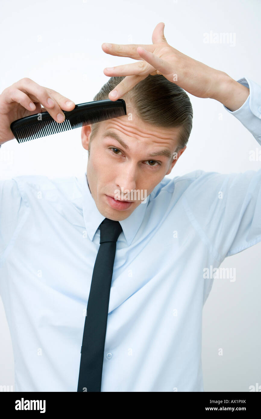 A mid adult man combing his hair Stock Photo - Alamy