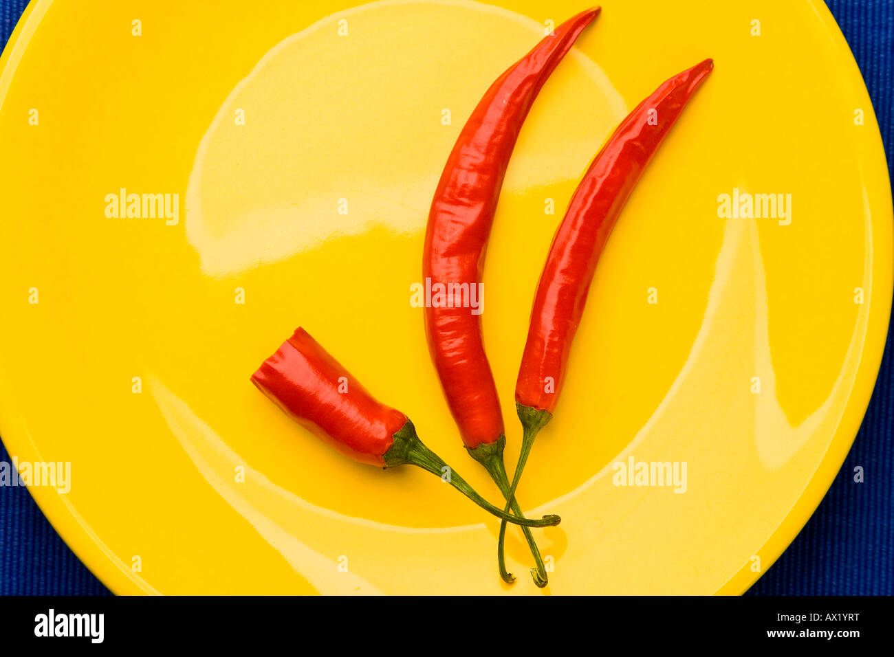 Red chili peppers on yellow plate Stock Photo - Alamy