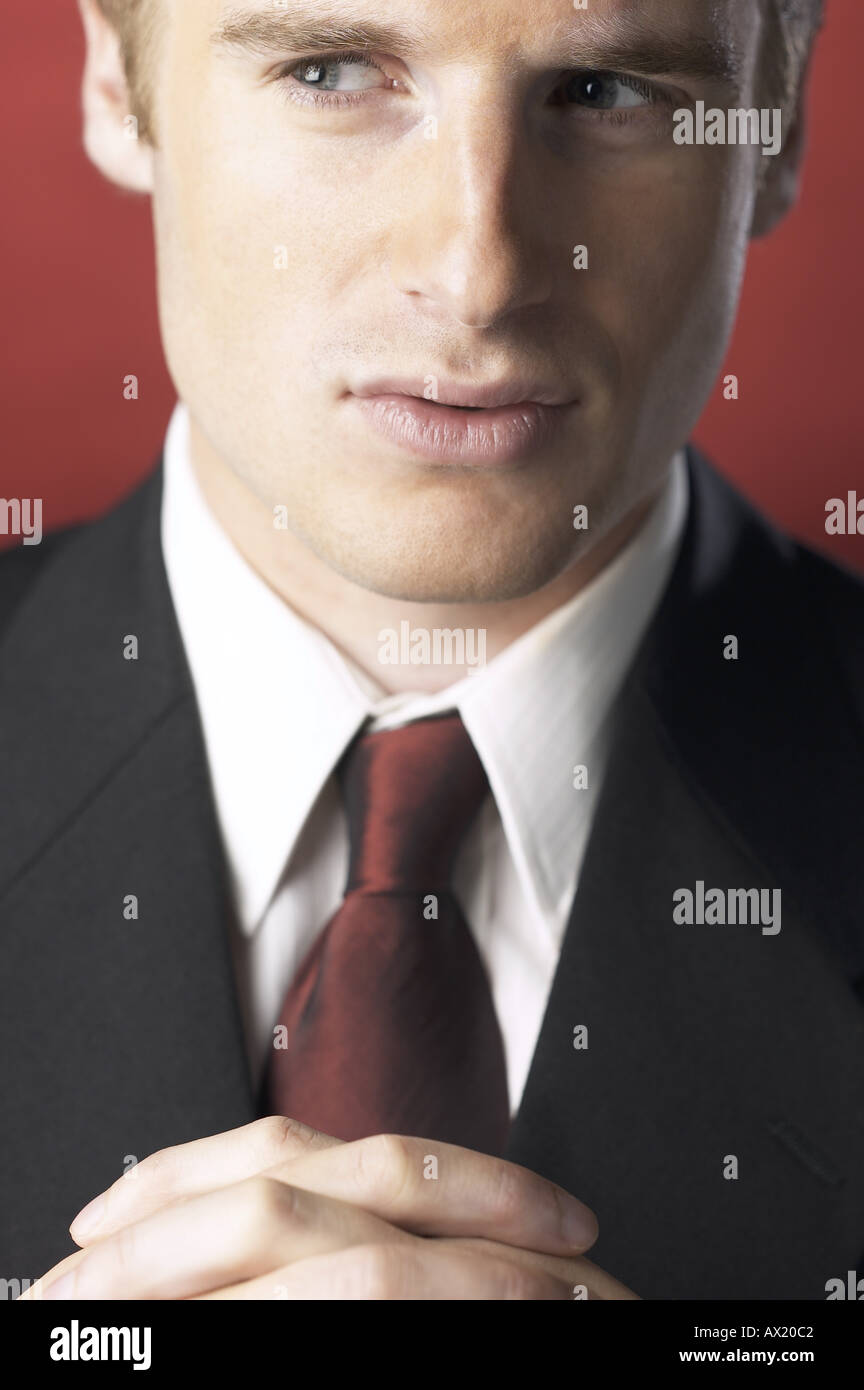 Man wearing suit and folding hands Stock Photo - Alamy