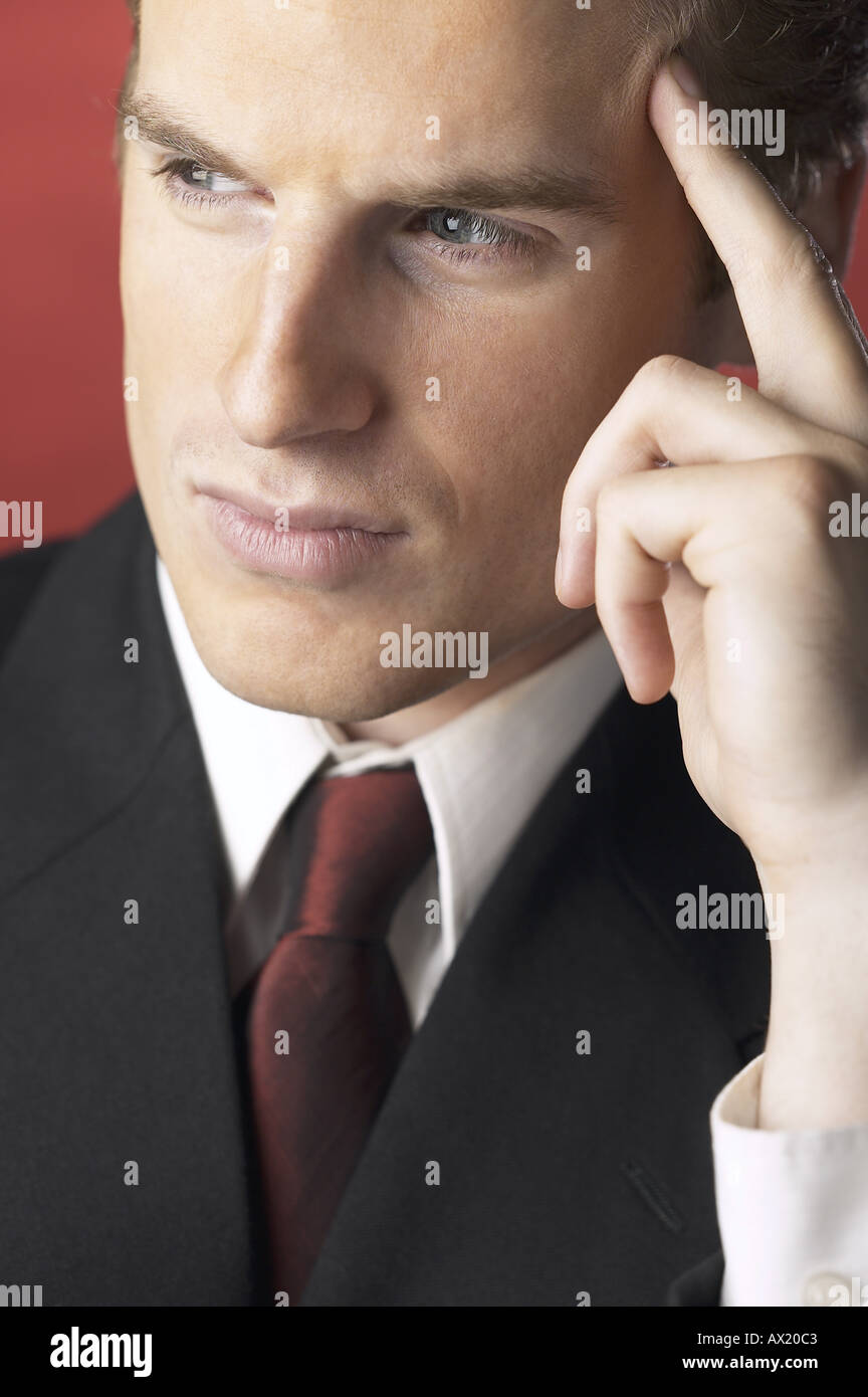 Man thinking with index finger at forehead Stock Photo - Alamy