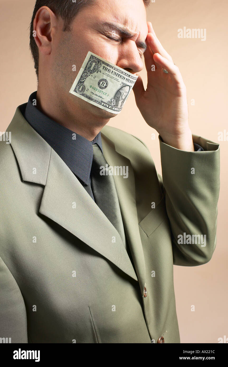 man with money over mouth BE 5 Stock Photo - Alamy