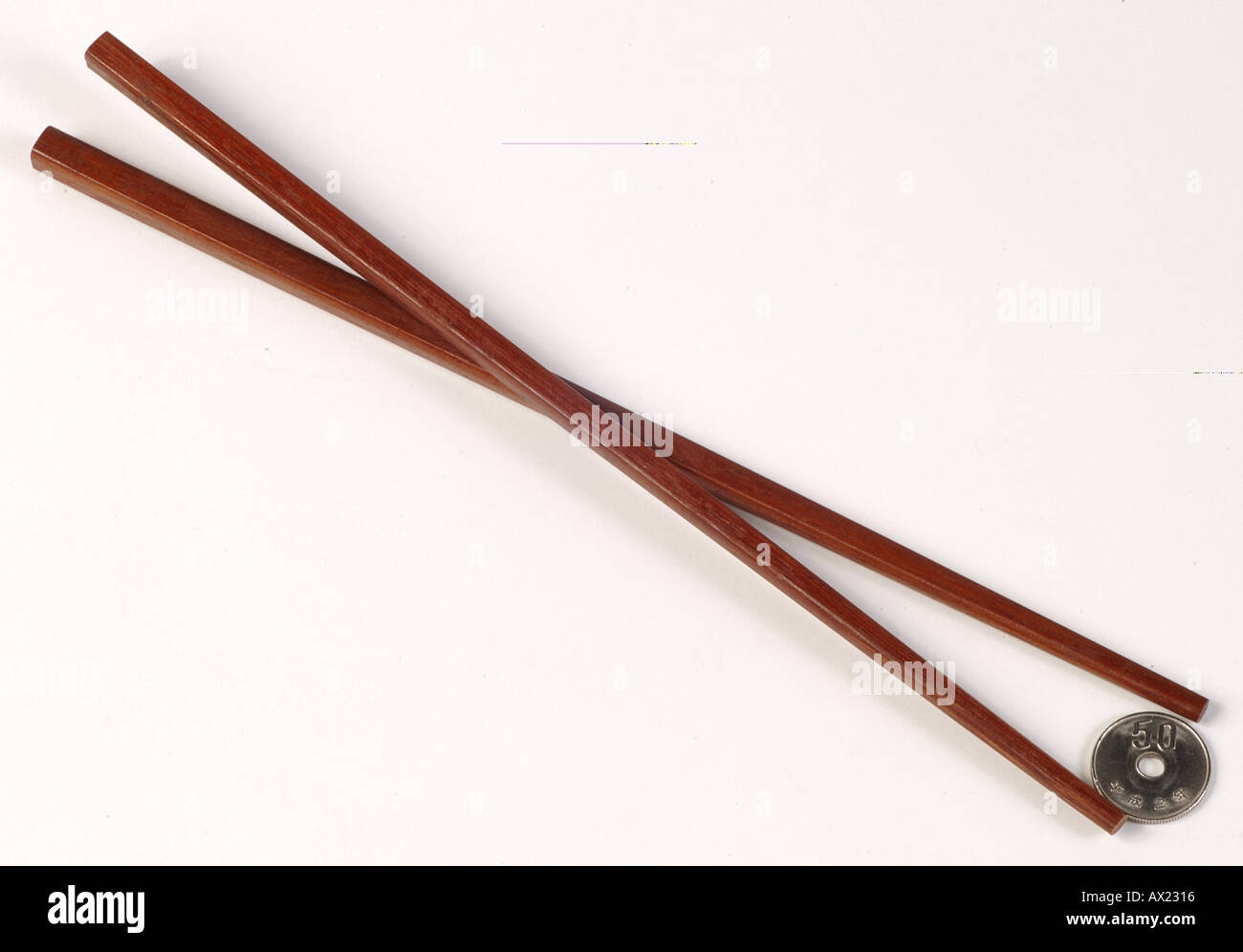 Chopsticks holding coin Stock Photo - Alamy