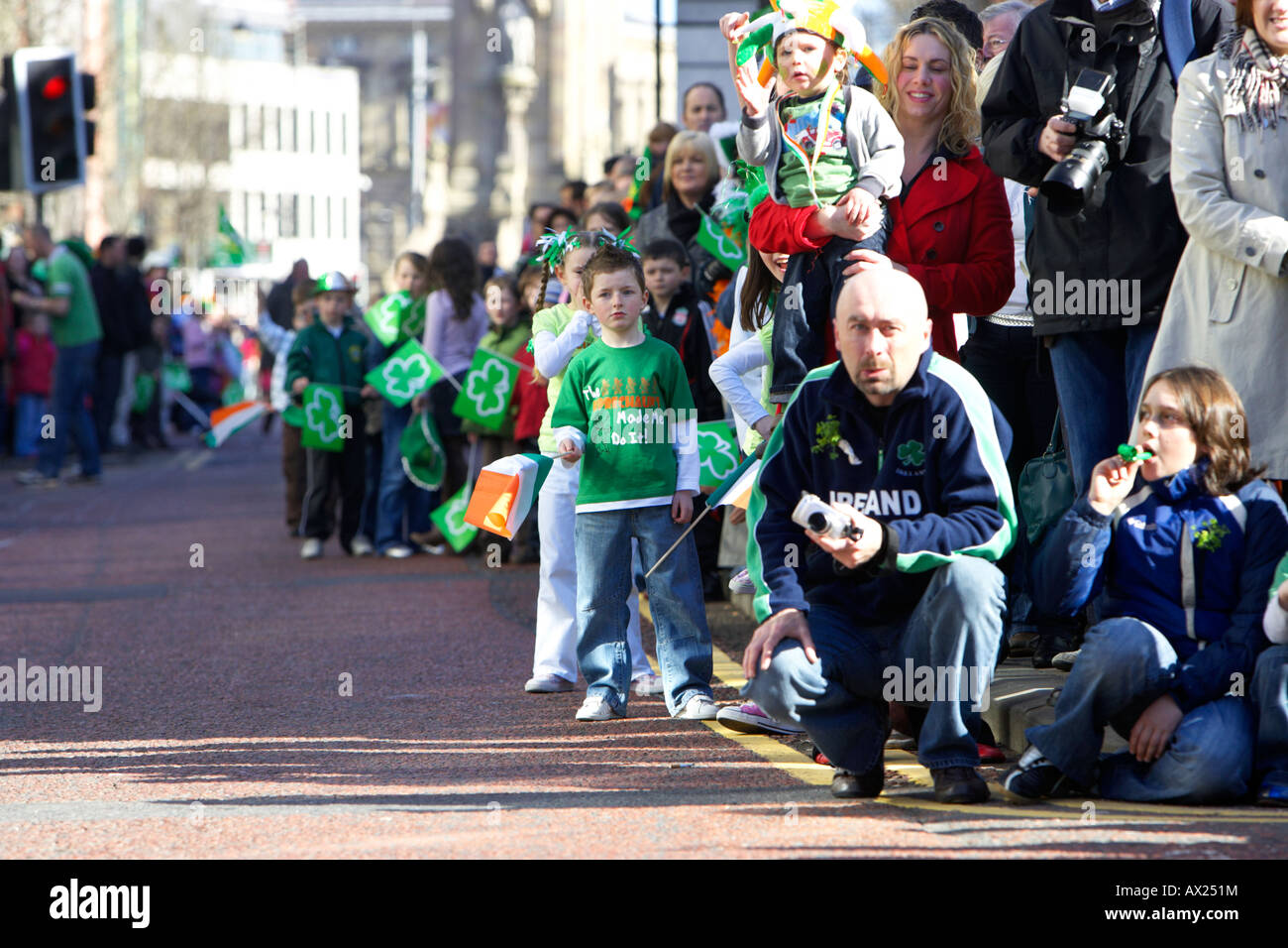 crowd of people lining the streets and road waiting on the parade and ...