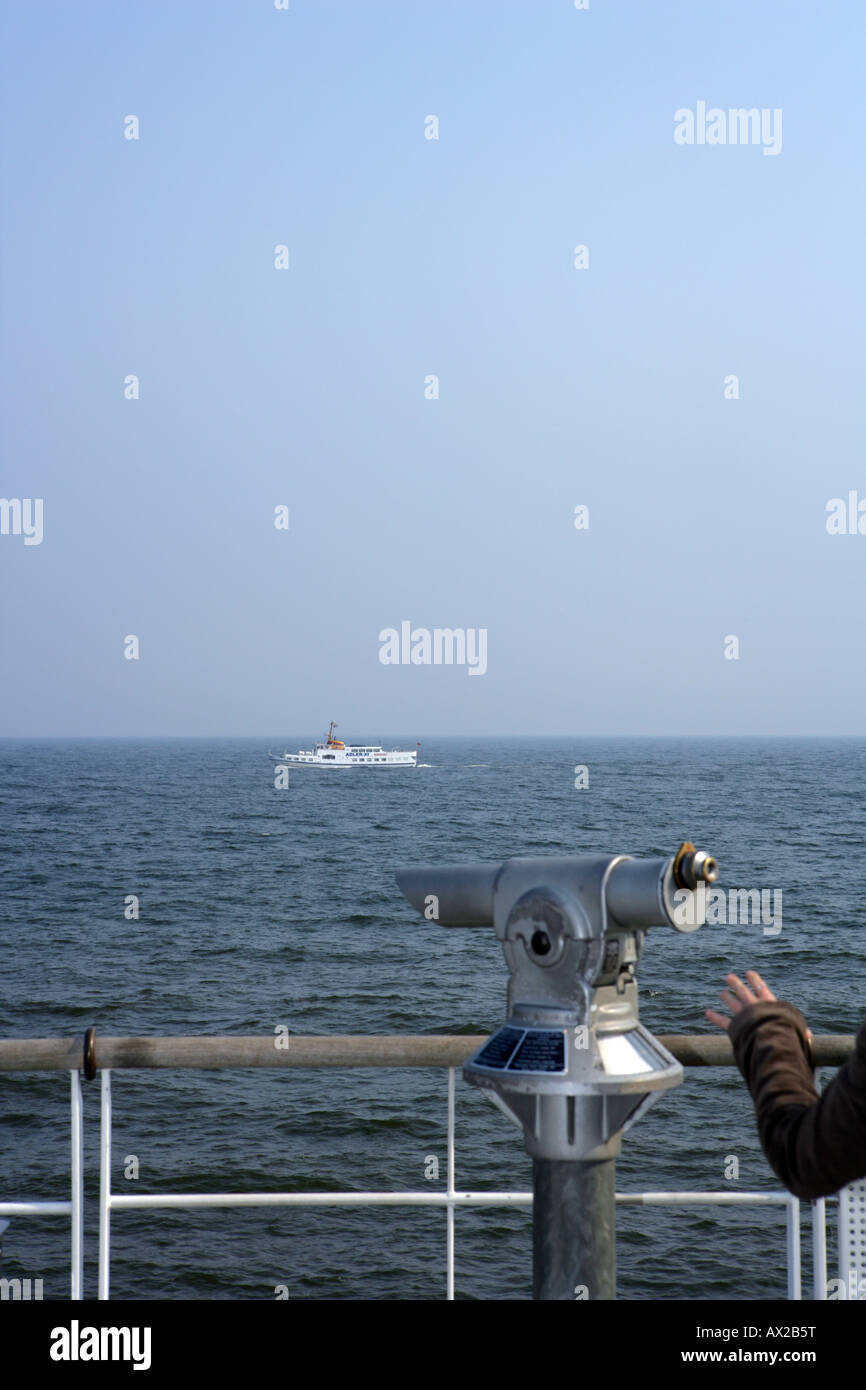 telescope at the sea in the background a boat Stock Photo - Alamy