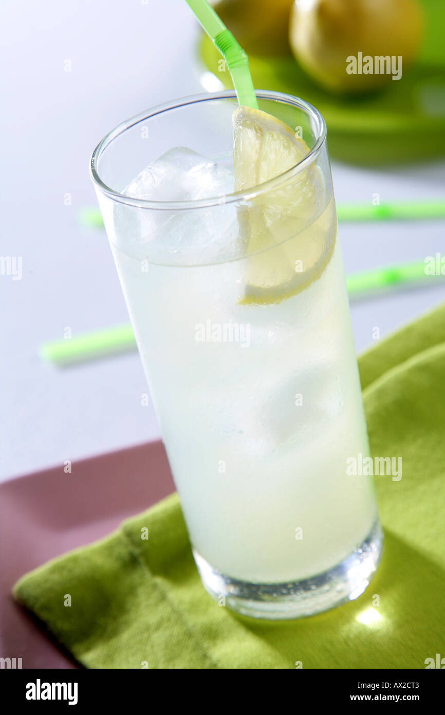 Lemon soft drink in a tall glass with green straw Stock Photo - Alamy
