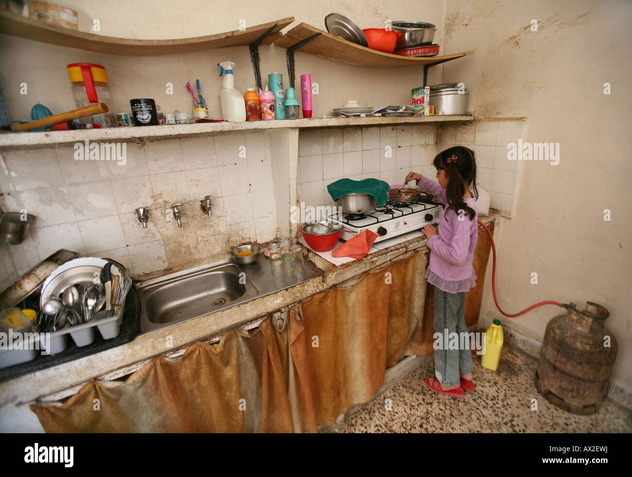 An Iraqi refugee girl prepares a meal for her family Many Iraqi ...