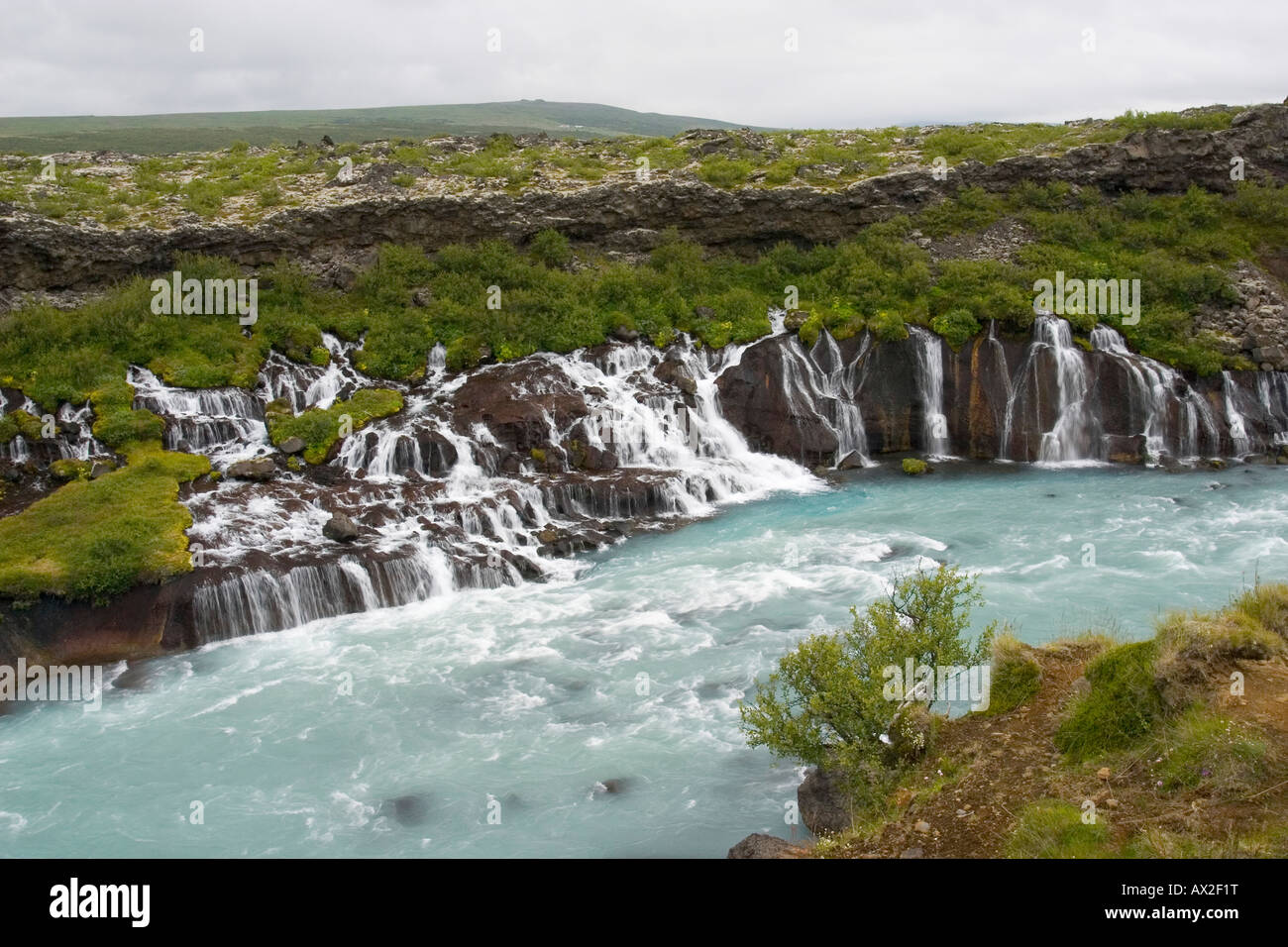 River Hvita sends glacial water flowing through layers of lava field at ...