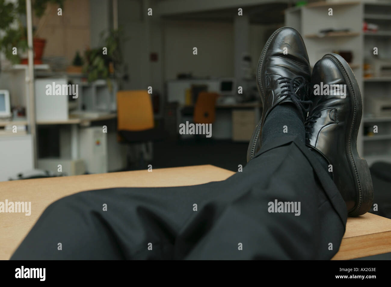 A man in a suit with his feet up on a table Stock Photo - Alamy