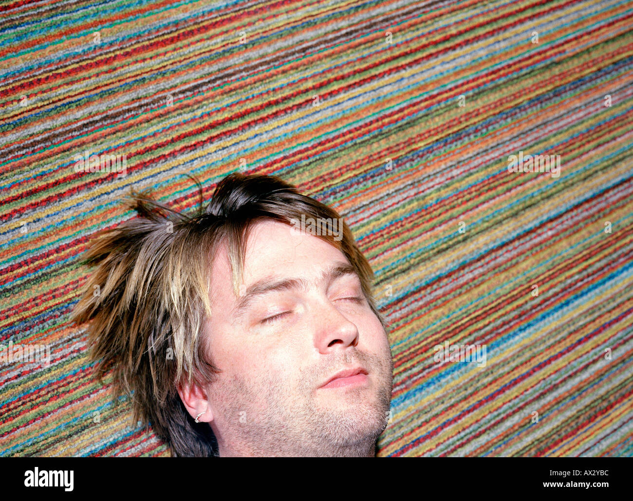 Man sleeping on multicolored carpet Stock Photo - Alamy