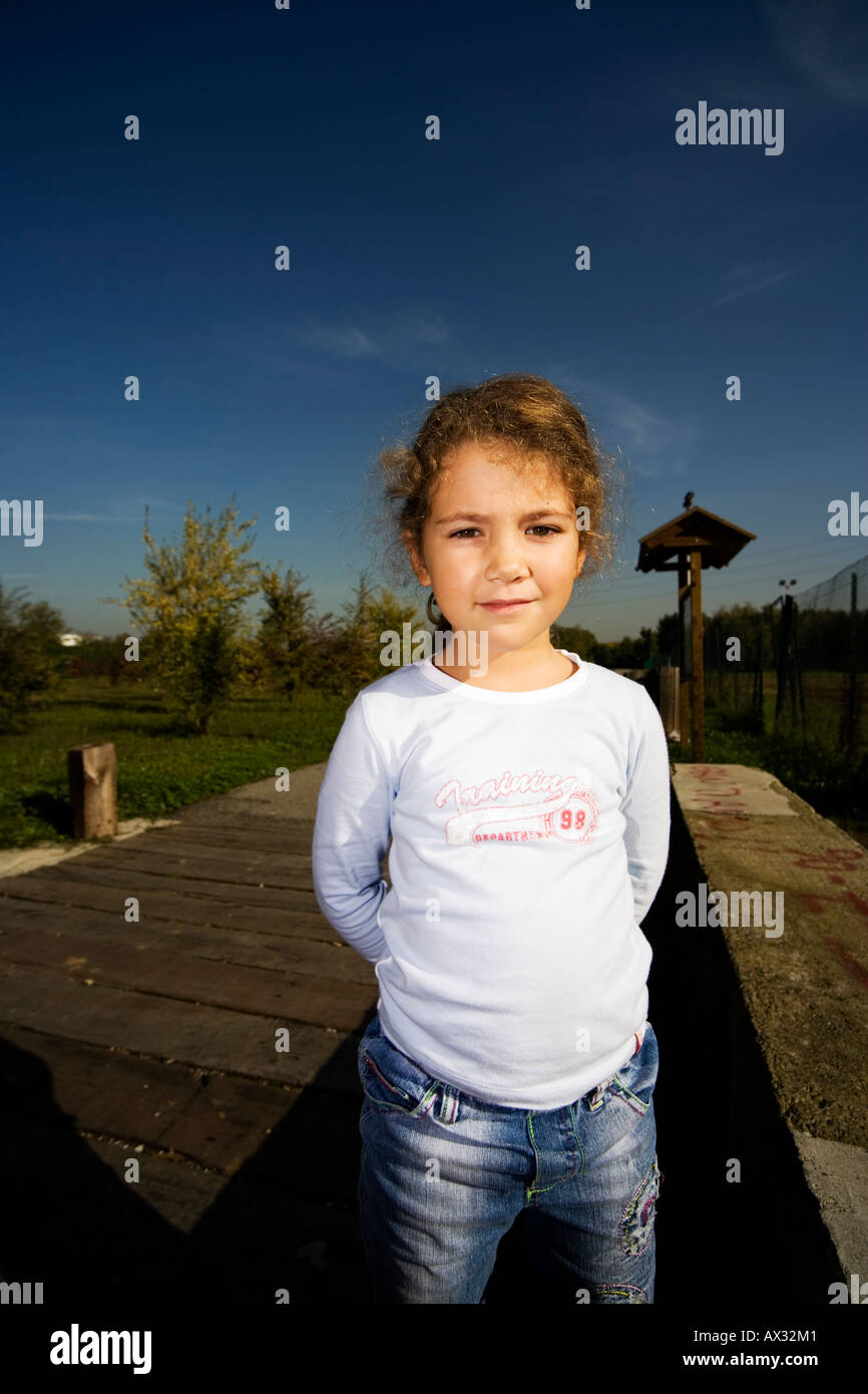 Little six years old child standing alone at the park Stock Photo - Alamy