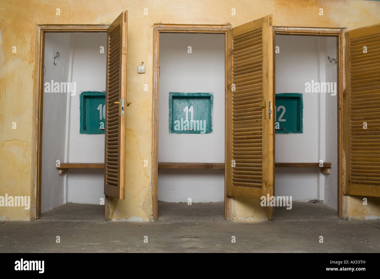 golden brown wall with three open doors with numbers inside ten eleven ...