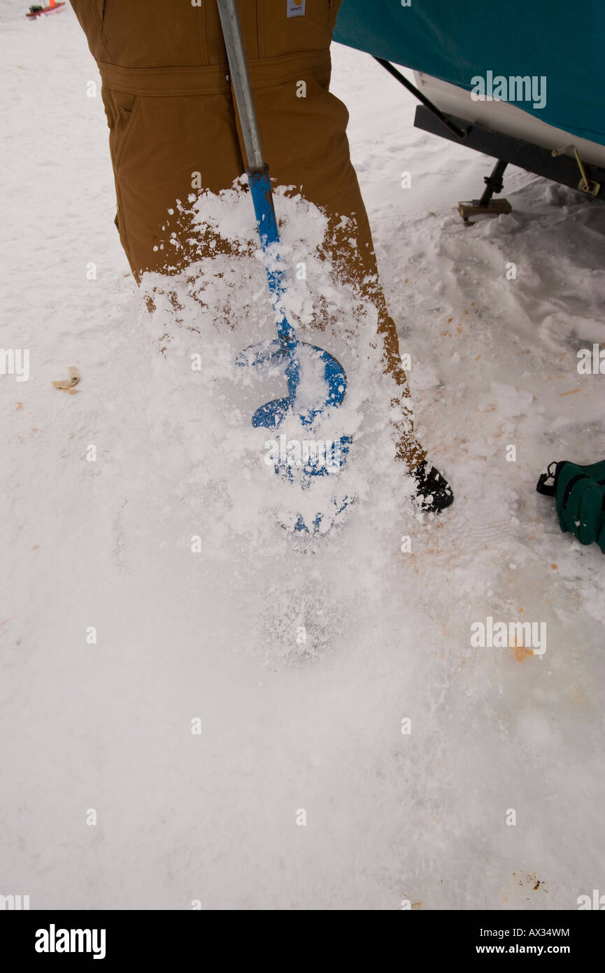 A MAN DRILLS A HOLE THROUGH THICK ICE WITH MANUAL ICE AUGER Stock Photo ...
