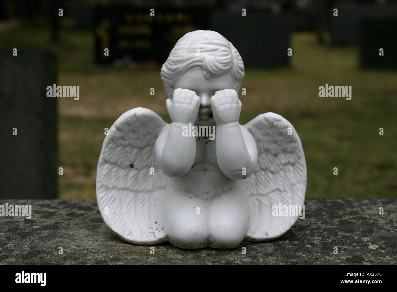 small angel statue on a grave Stock Photo - Alamy