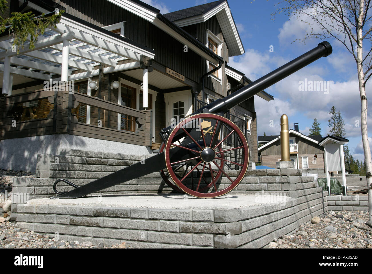 Decoration cannon in front of cottage Stock Photo - Alamy