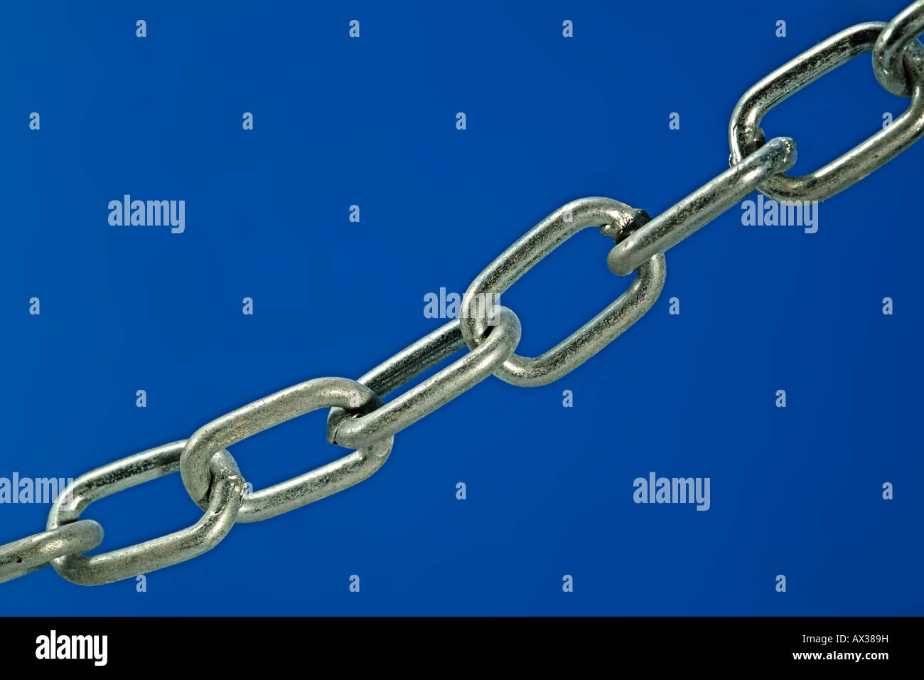 A macro of a metal chain with a blue background Stock Photo - Alamy