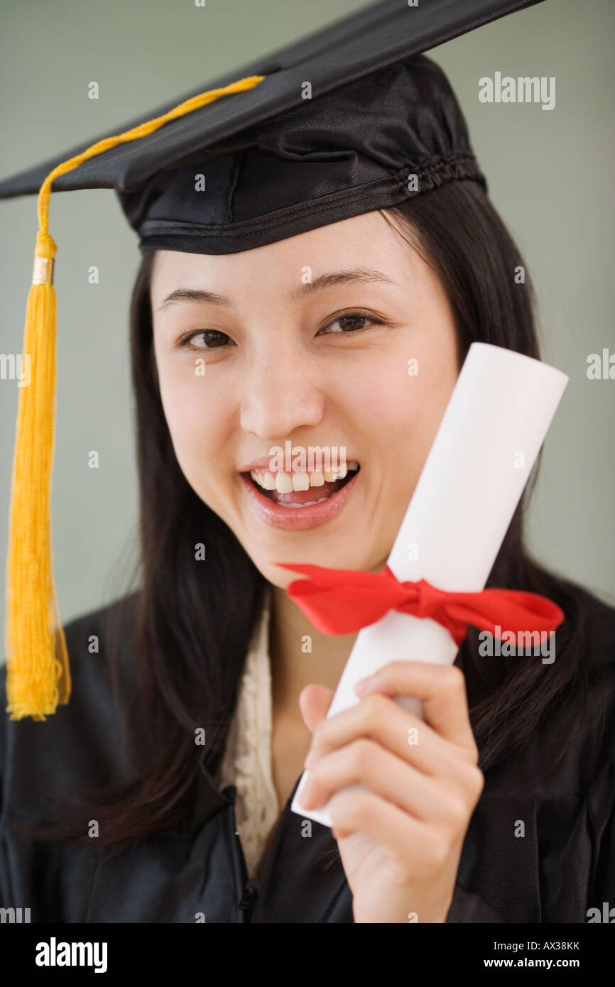 Asian woman wearing graduation cap and holding diploma Stock Photo - Alamy