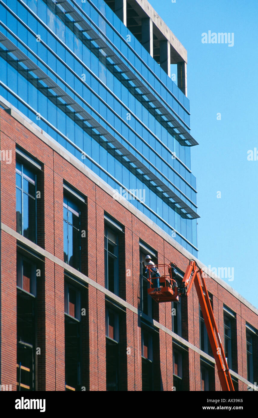 Model Released Construction workers installing windows in high rise ...
