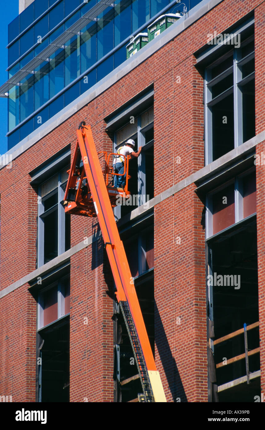 Model Released Construction workers installing windows in high rise ...