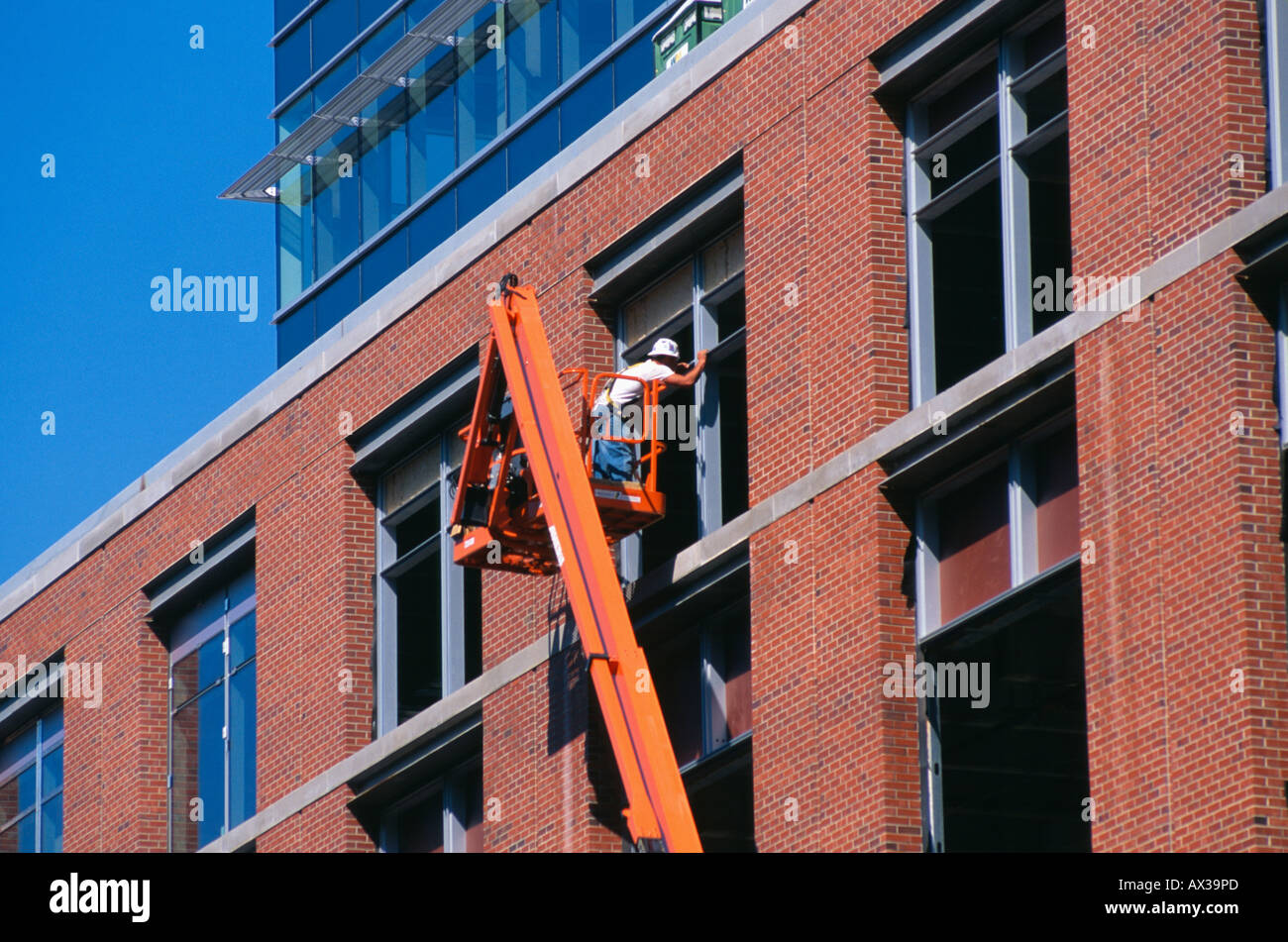 Model Released Construction workers installing windows in high rise ...