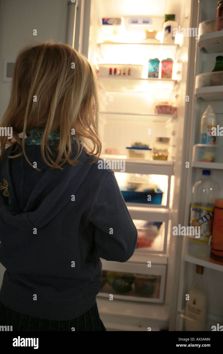 young girl looking in open fridge Stock Photo - Alamy