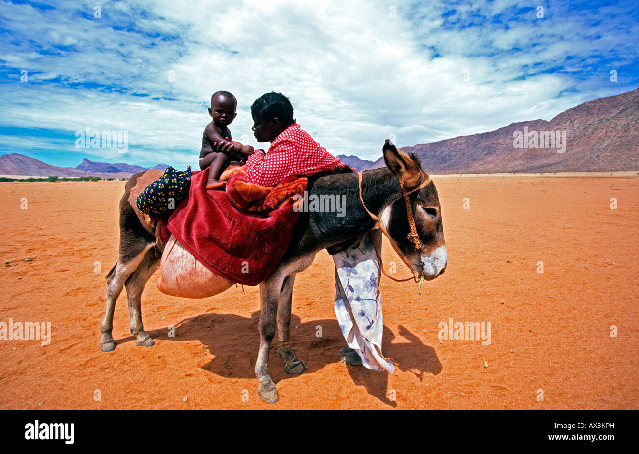 Himba Woman with baby Travelling on a Donkey Through Dry Marienfluss ...