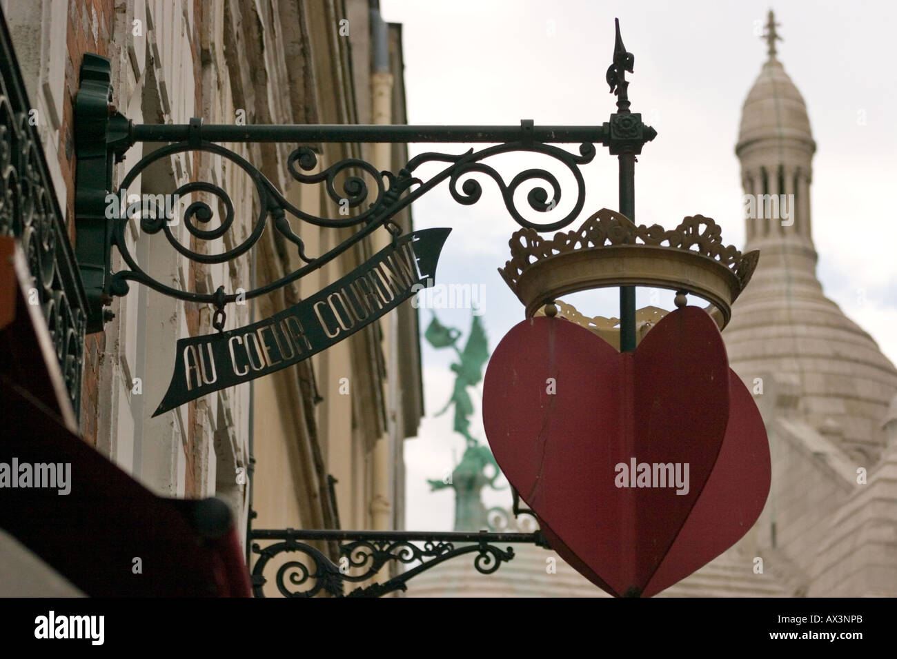 Hanging street sign with the dome of Sacre Coeur in the background ...