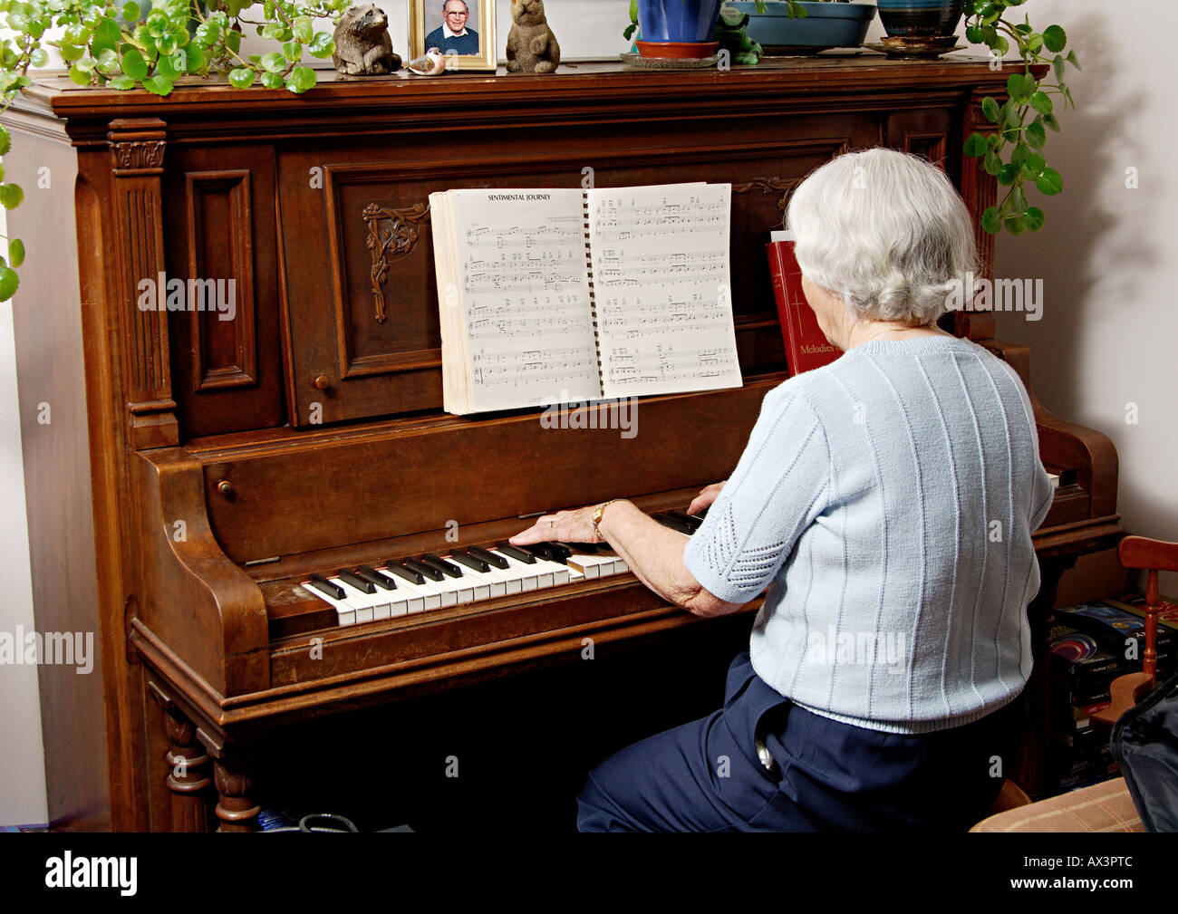 View of an elderly woman playing a piano Stock Photo - Alamy