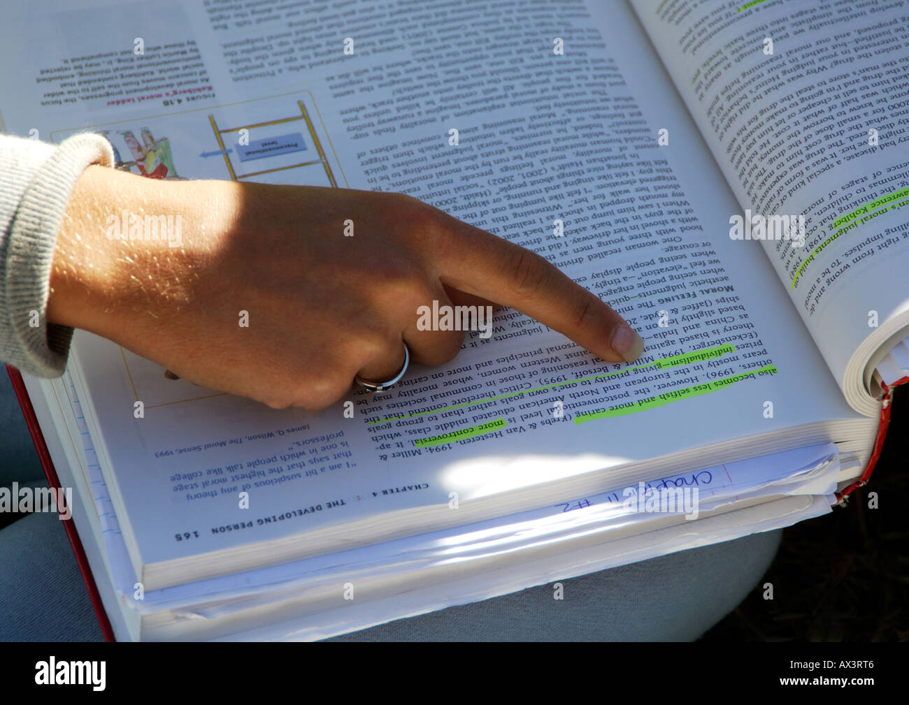 A student is pointing at a highlighted line in a book Stock Photo - Alamy