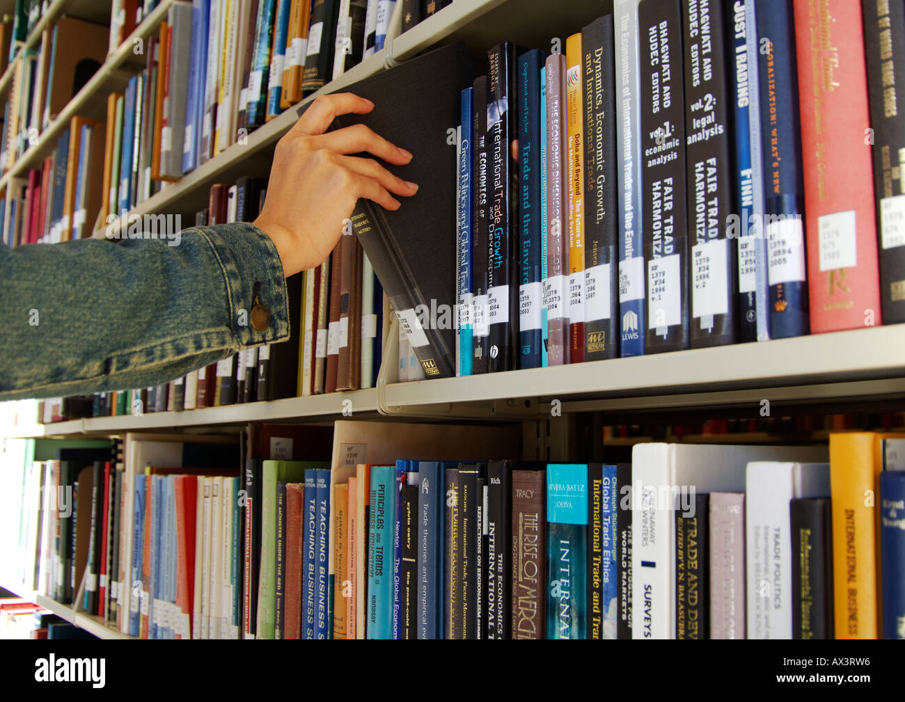 A person picking a book from a library Stock Photo - Alamy